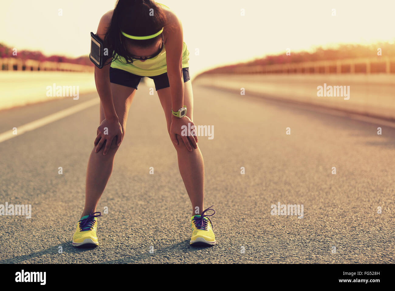 tired woman runner taking a rest after running hard on city road Stock ...