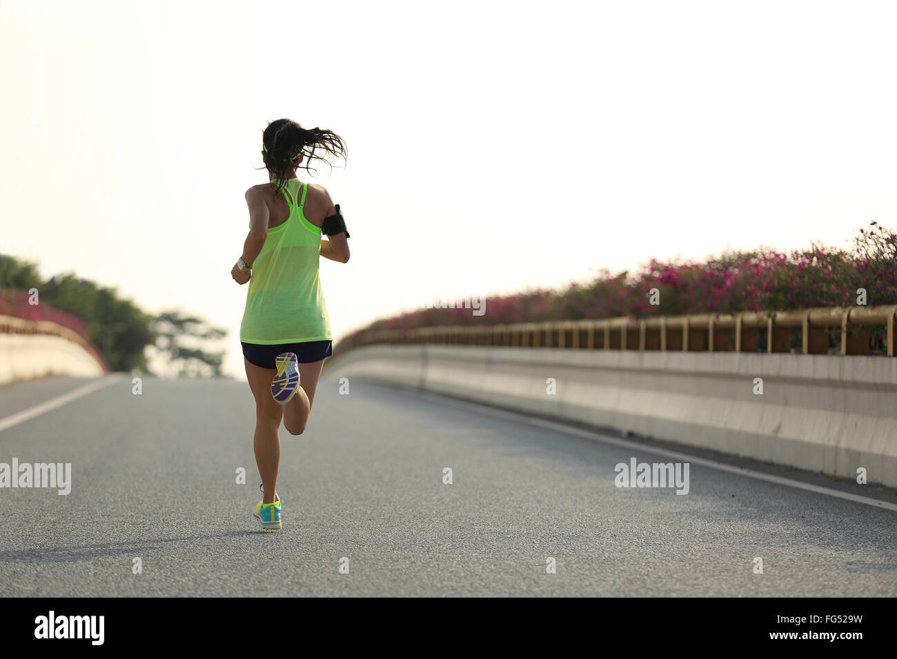 young woman runner running on city road Stock Photo - Alamy