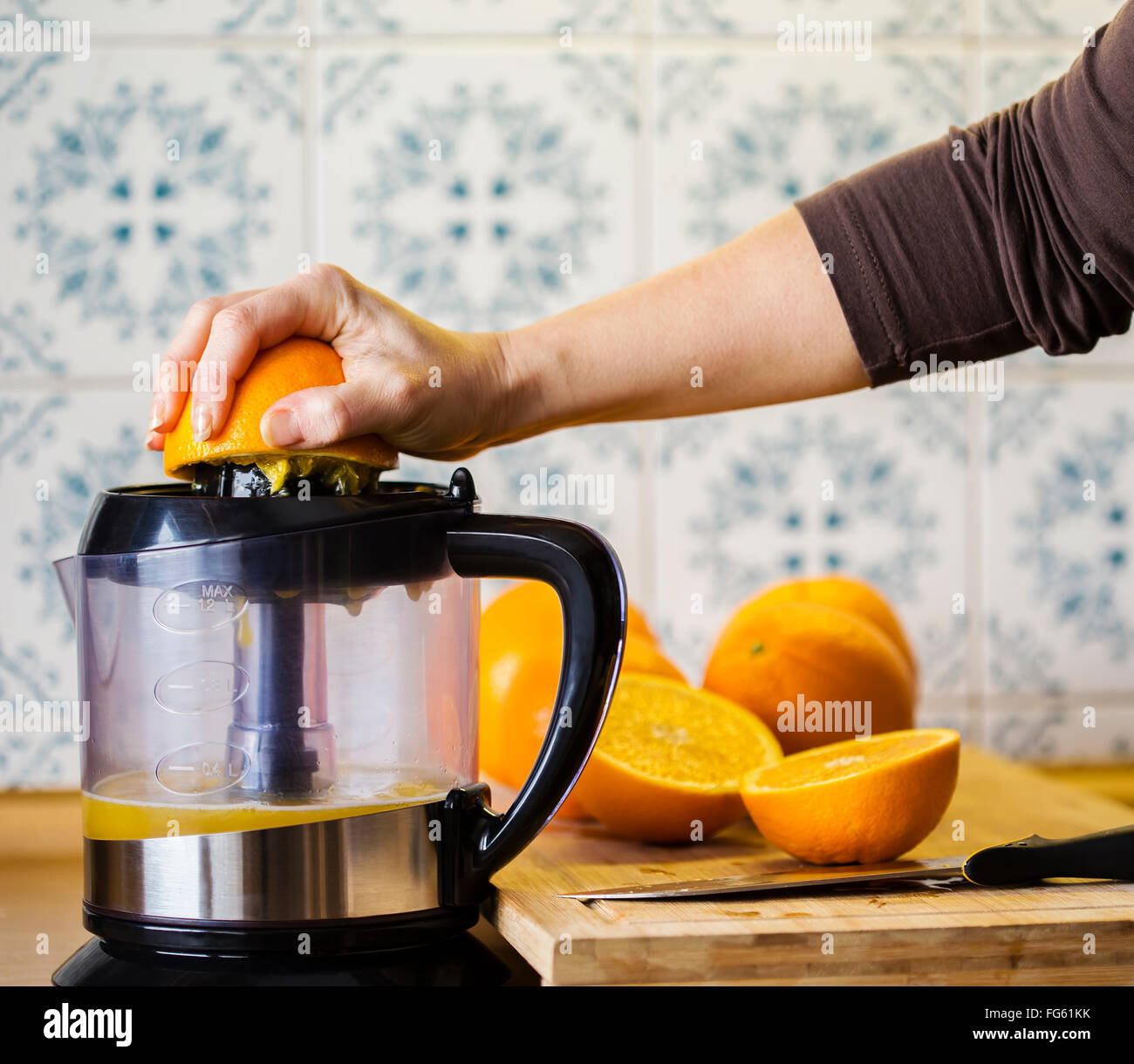 Squeezing orange to extract some healthy juice Stock Photo - Alamy
