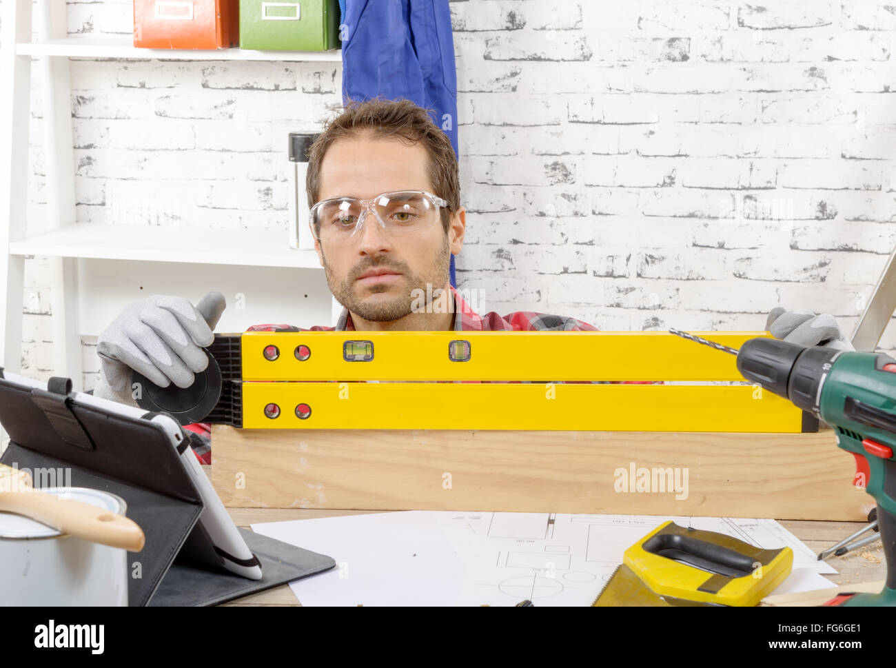 a young man viewing a spirit level, to read the position of the bubble ...