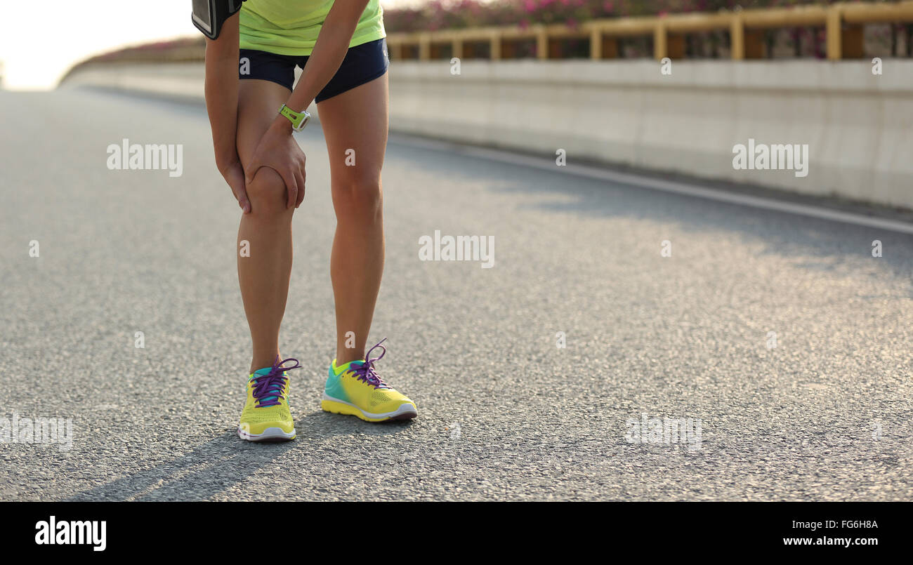 woman runner hold her injured leg on road Stock Photo - Alamy