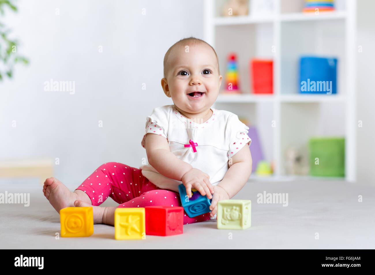 Baby girl playing cubes block toys Stock Photo - Alamy