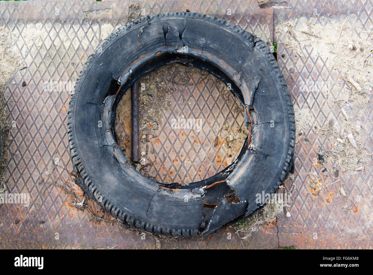 Completely torn tyre abandoned on a rusty metal plate Stock Photo - Alamy