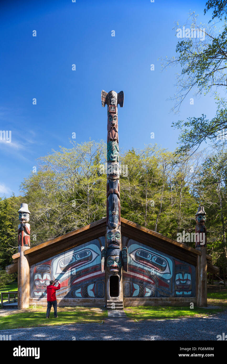 Tourist photographs a totem pole and a clan house, Totem Bight Historic ...