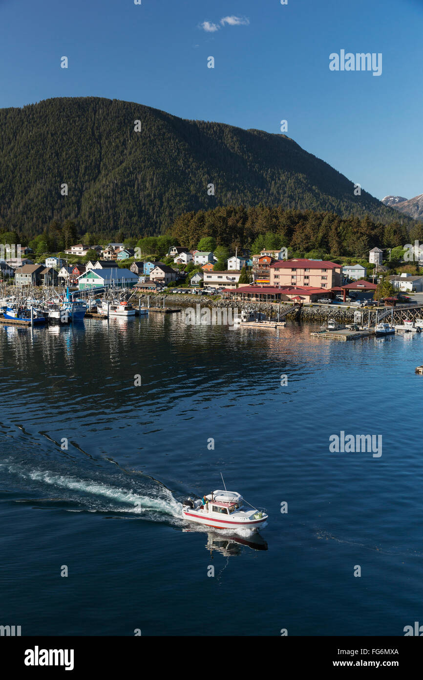 A small boat departs from Sitka Harbor on a clear day, Southeast Alaska ...