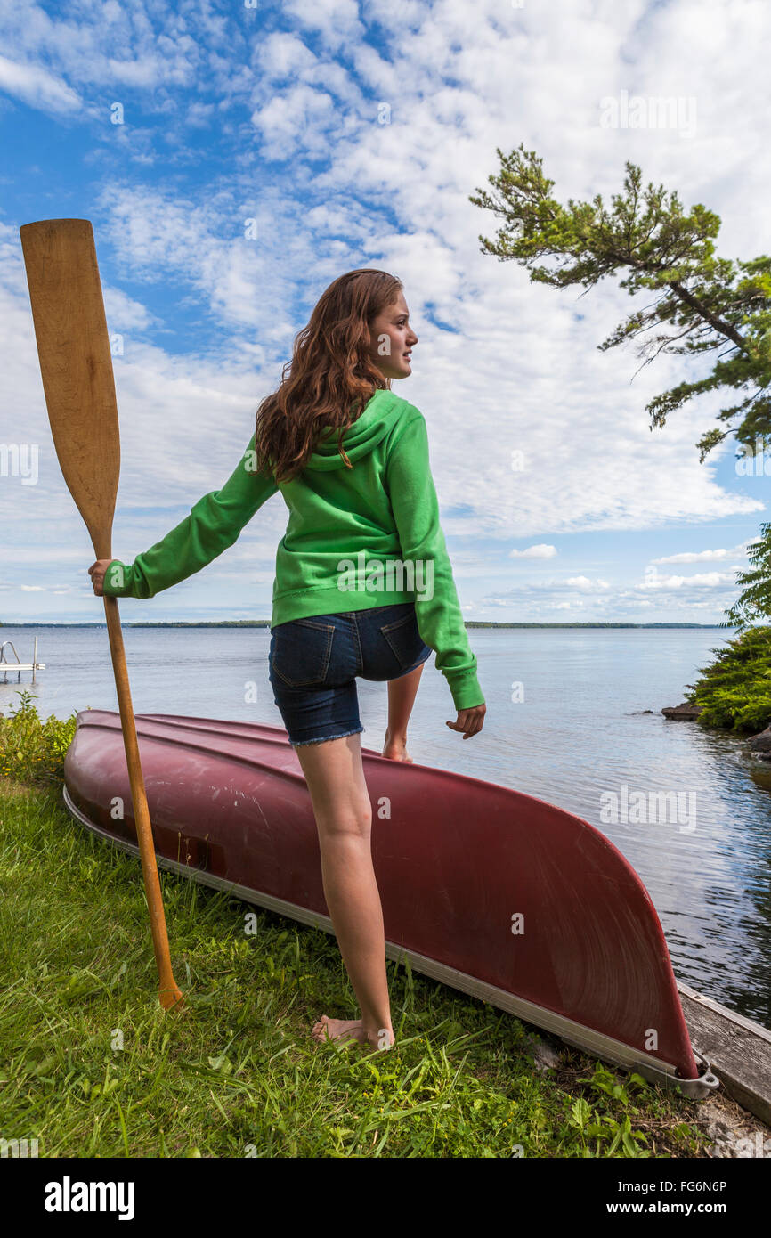 Girl holding paddle with canoe by Balsam Lake; Ontario, Canada Stock ...