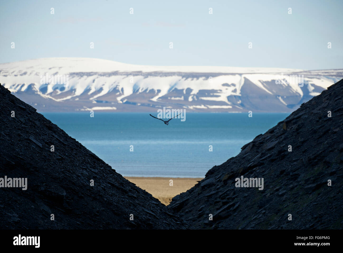 View through mountain slopes to the beach, Arctic ocean, snow covered ...