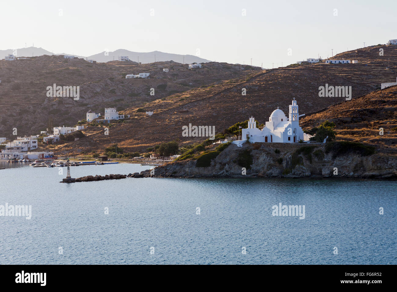 Port and white church on a cliff at the water's edge; Ios, Greece Stock ...