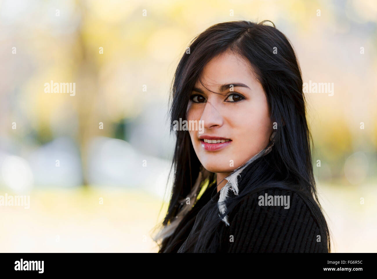 A young aboriginal female model smiles and looks at the camera in a ...