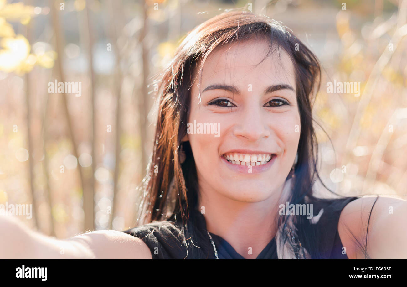A young aboriginal female model takes a playful fun selfie outdoors in ...