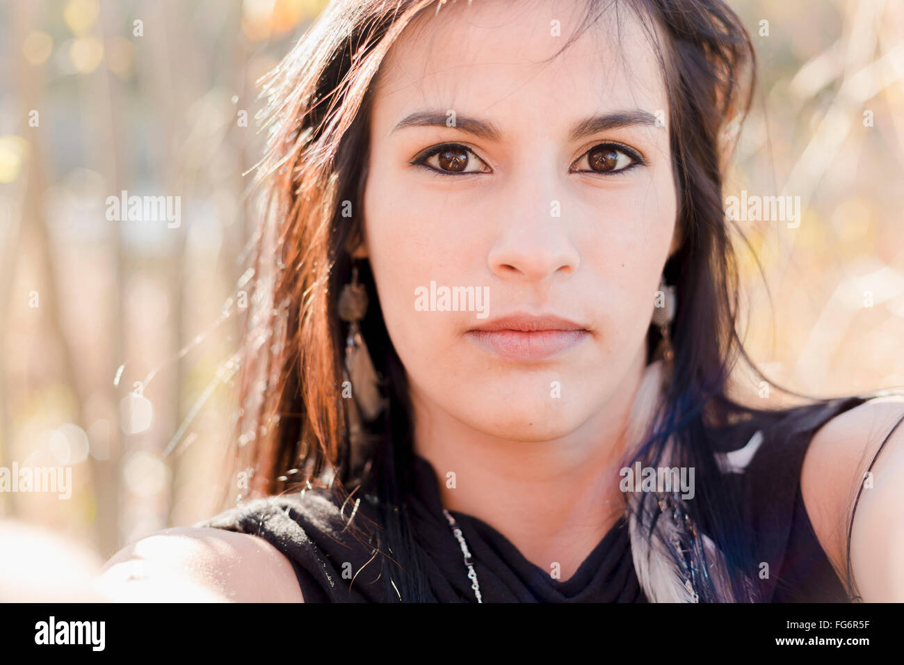 A young aboriginal female model looks at the camera in a concentrated ...
