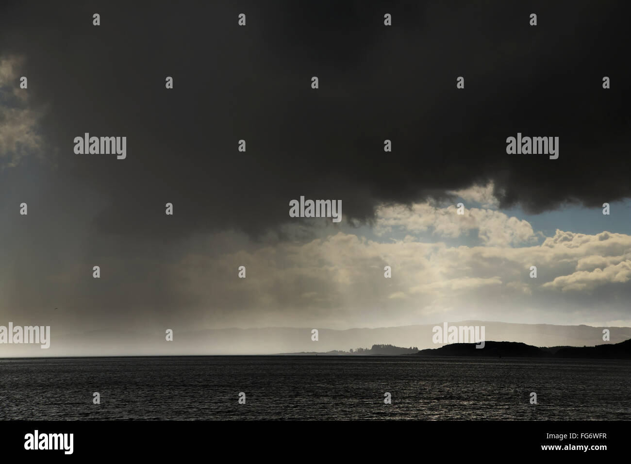 Rain falling from ominous dark clouds over the water; Otter Ferry ...