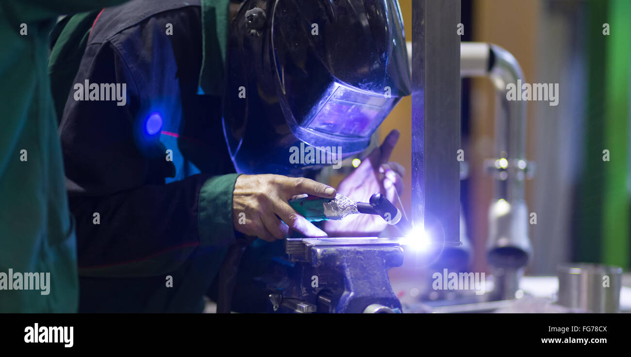 Industrial worker welding in metal factory Stock Photo - Alamy