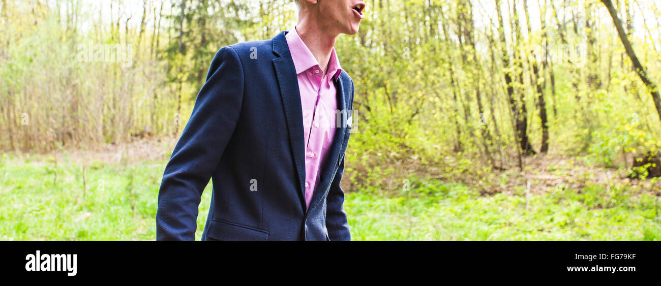 Young man standing alone in woods and yelling Stock Photo - Alamy