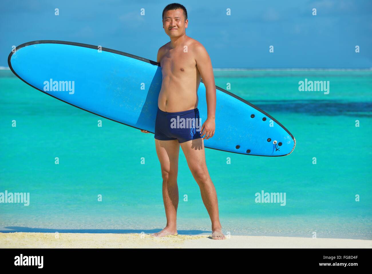 Man with surf board on beach Stock Photo - Alamy