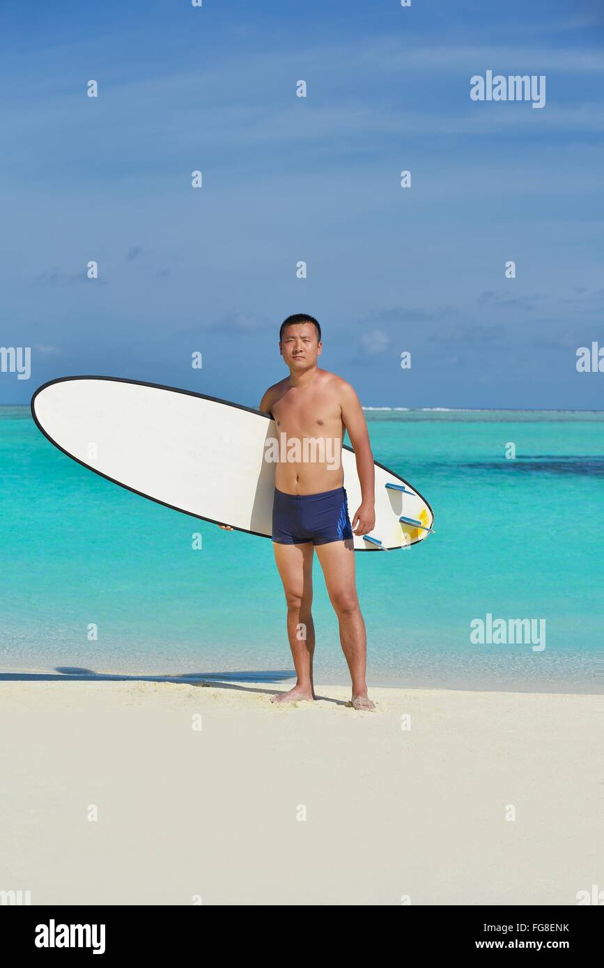 Man with surf board on beach Stock Photo - Alamy