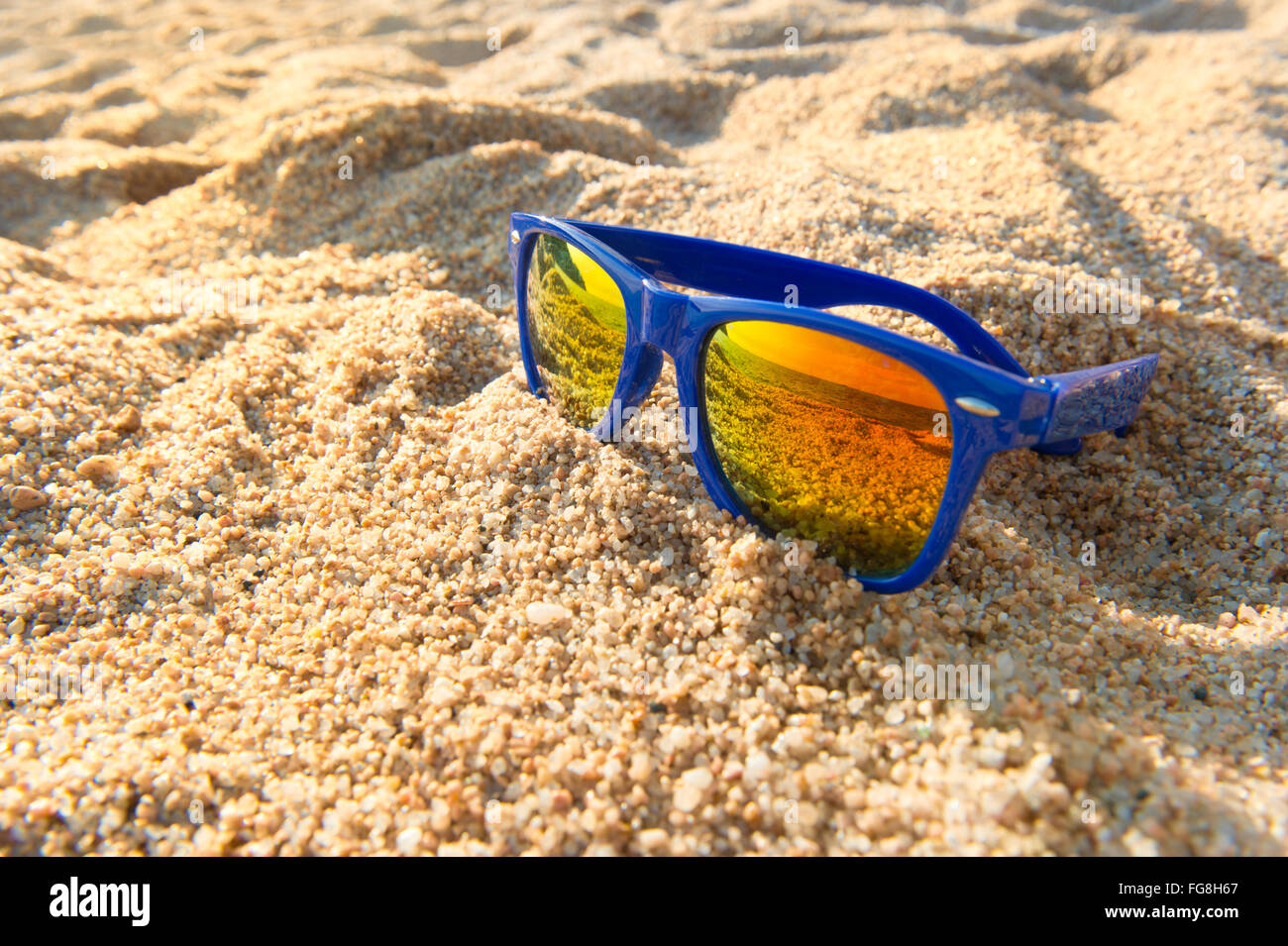 Sunglasses with mirrorring sunset at the beach Stock Photo - Alamy