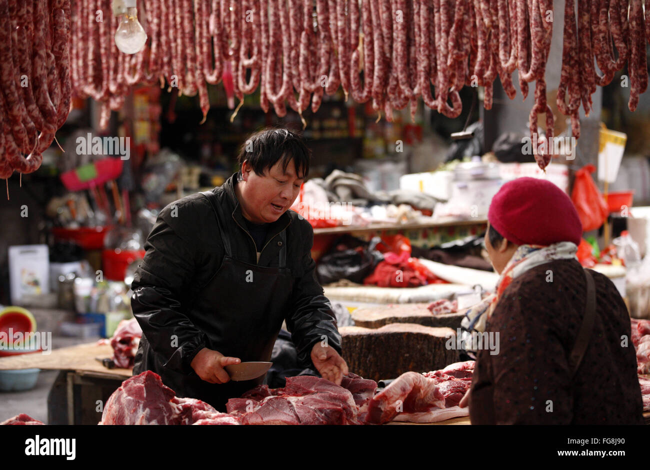An vendor is selling meat to a customer in a food market in Huaibei ...