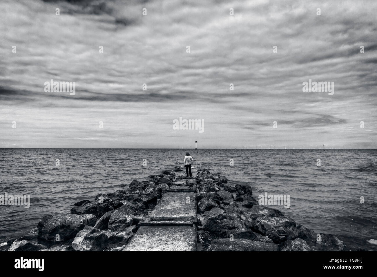 Black and white picture of a mature lady standing at the end of a wave ...