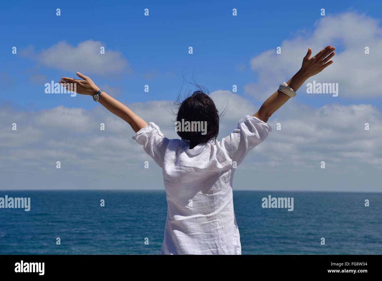 young woman with spreading arms to sky Stock Photo - Alamy