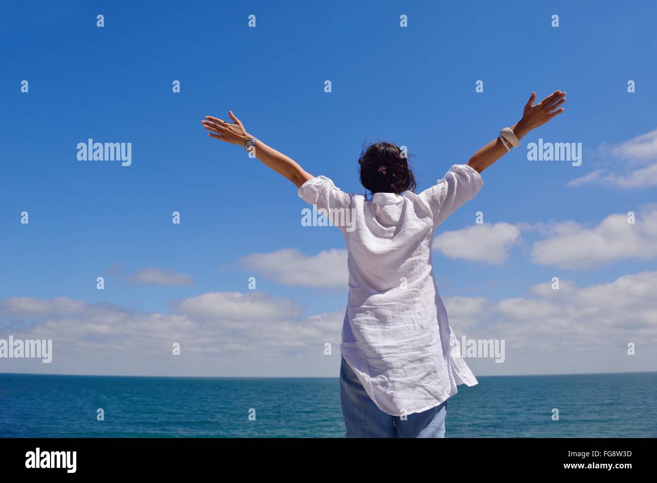 young woman with spreading arms to sky Stock Photo - Alamy