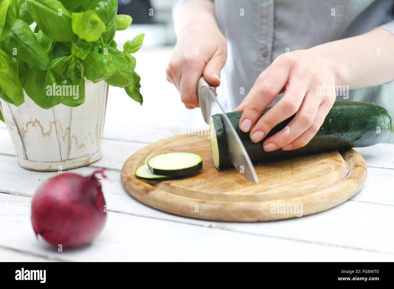Zucchini, woman preparing a meal. Hands woman standing in the kitchen ...