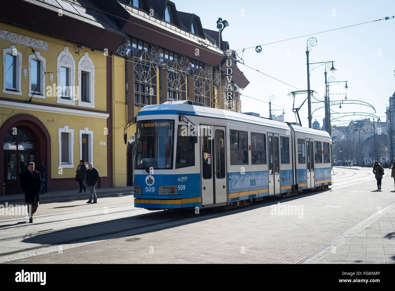 Blue tram on sunlit street of old European town Stock Photo - Alamy