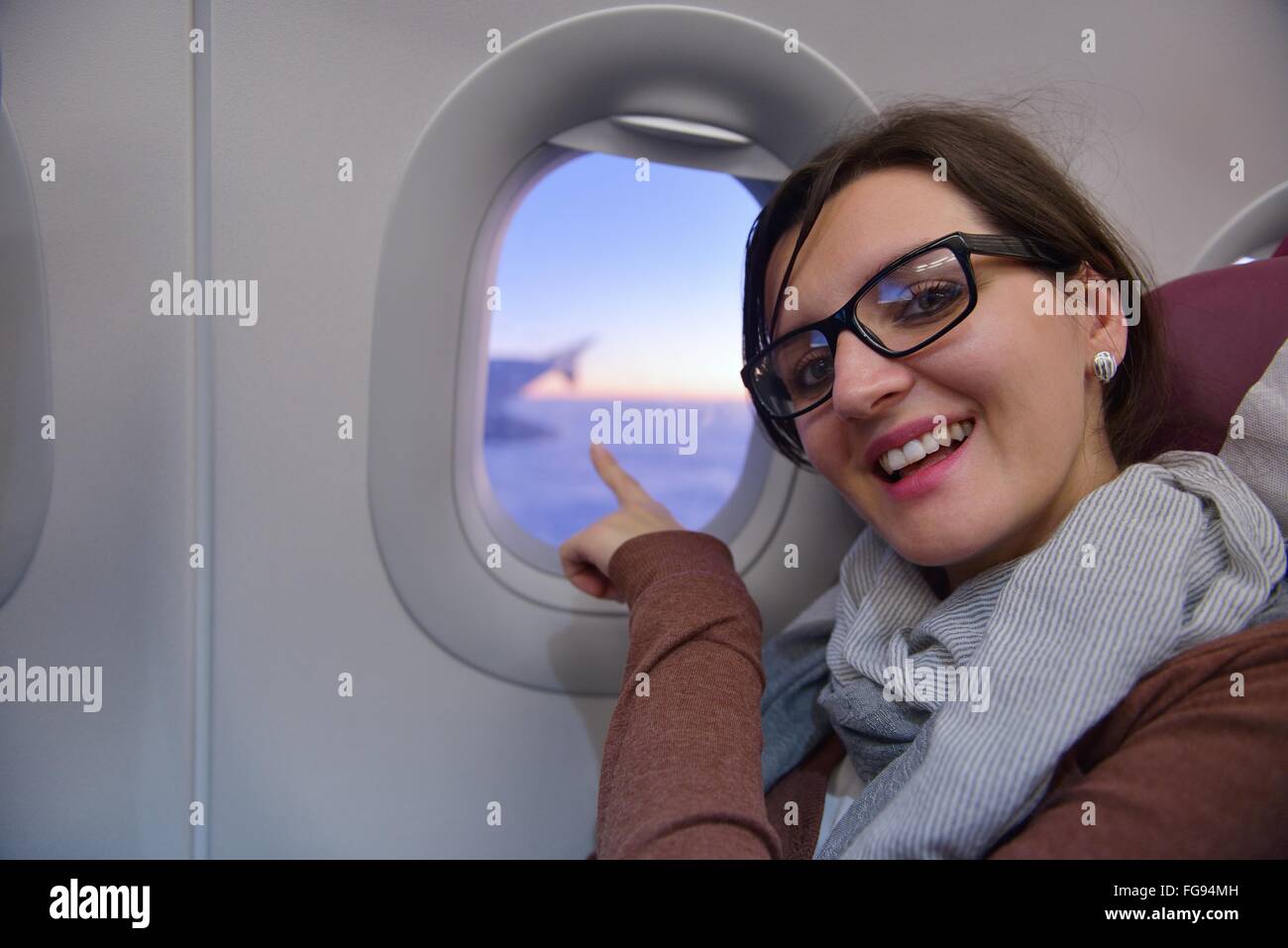 Woman looking through window of plane hi-res stock photography and ...