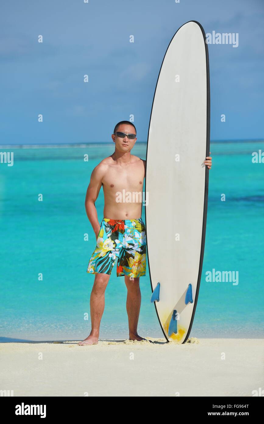 Man with surf board on beach Stock Photo - Alamy