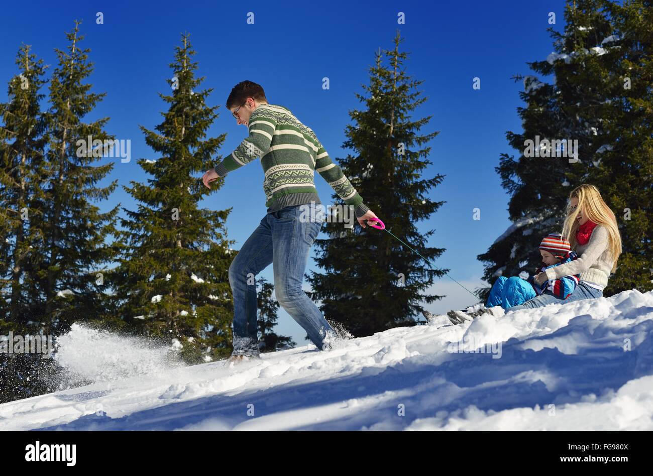family having fun on fresh snow at winter vacation Stock Photo - Alamy