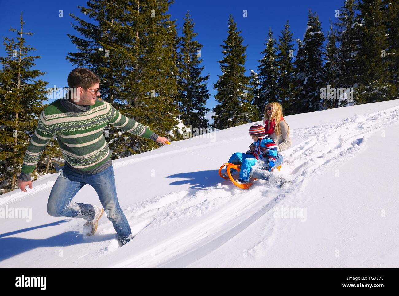 family having fun on fresh snow at winter vacation Stock Photo - Alamy