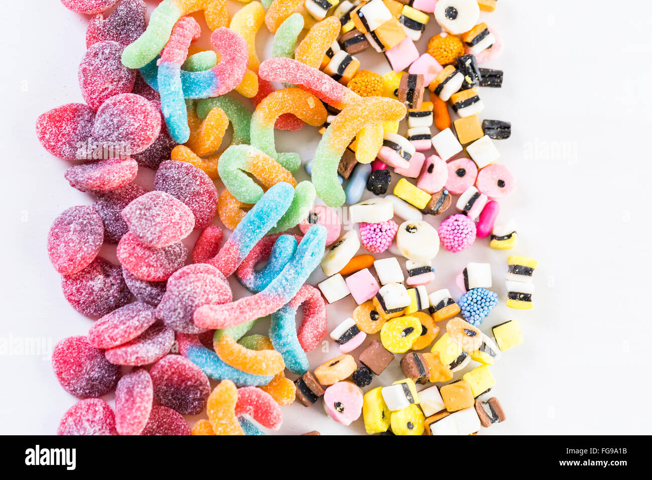 Multicolored candies on a white table Stock Photo - Alamy