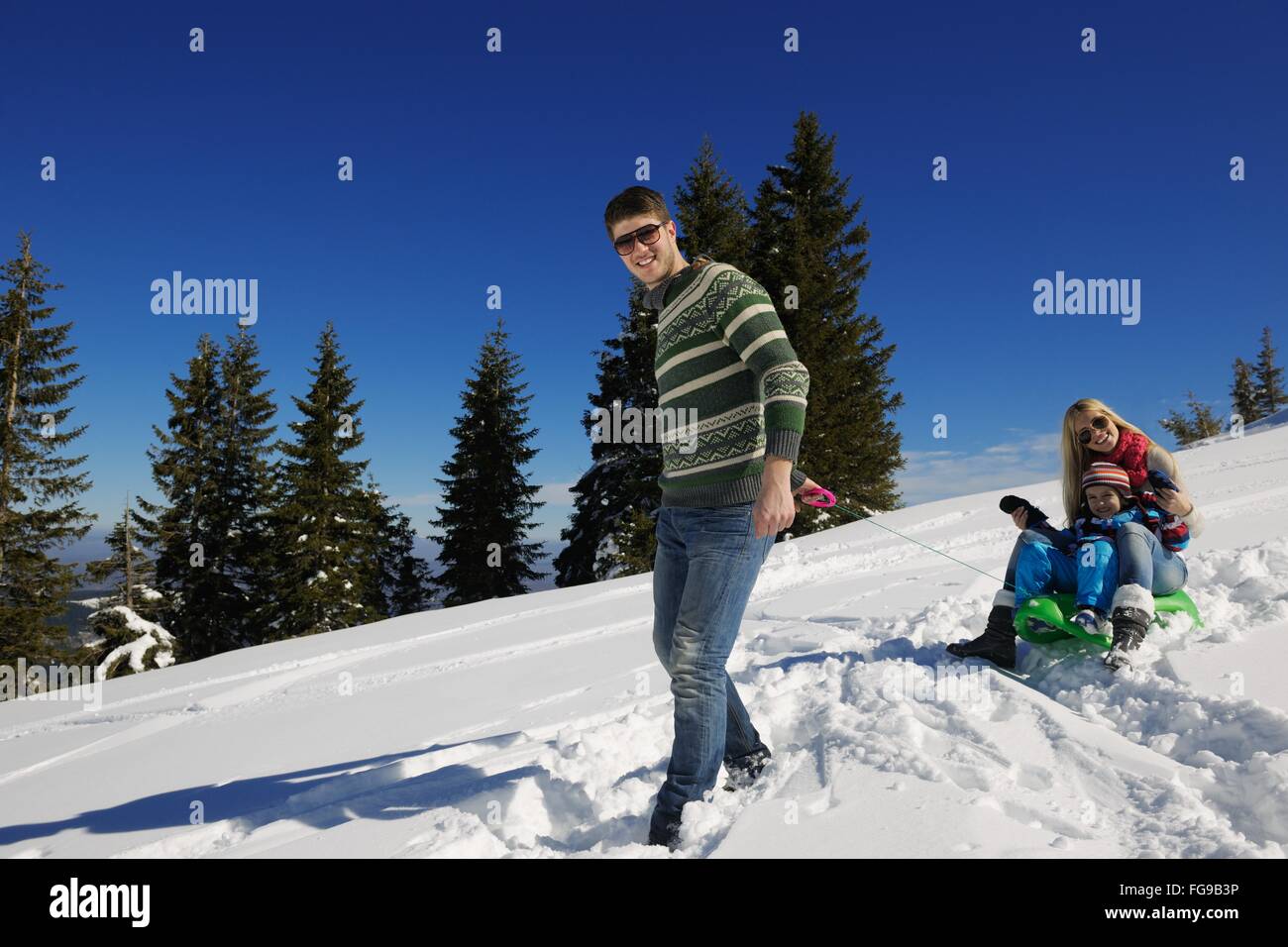 family having fun on fresh snow at winter vacation Stock Photo - Alamy