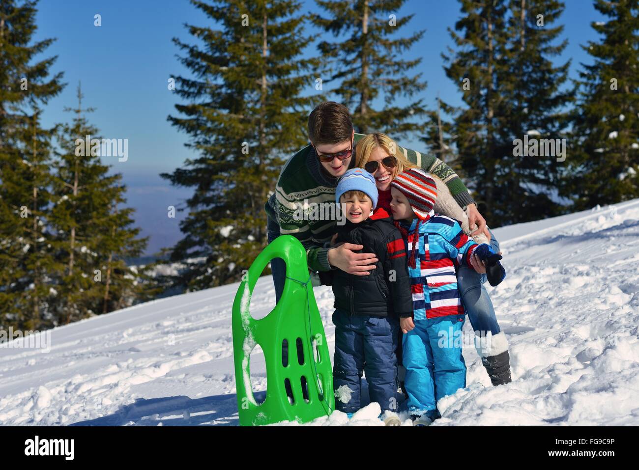 family having fun on fresh snow at winter vacation Stock Photo - Alamy