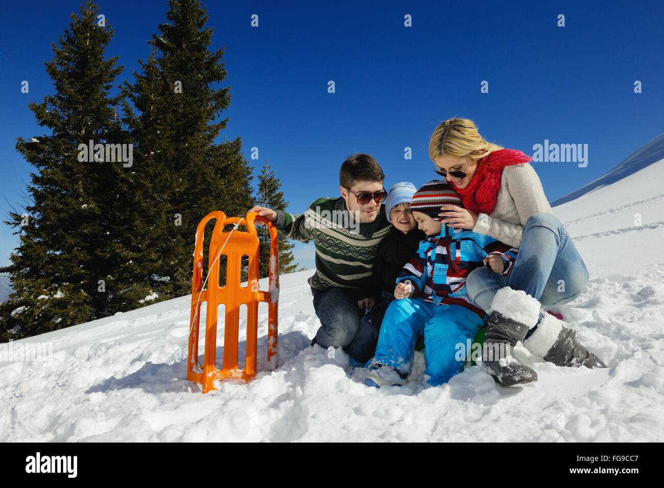 family having fun on fresh snow at winter vacation Stock Photo - Alamy