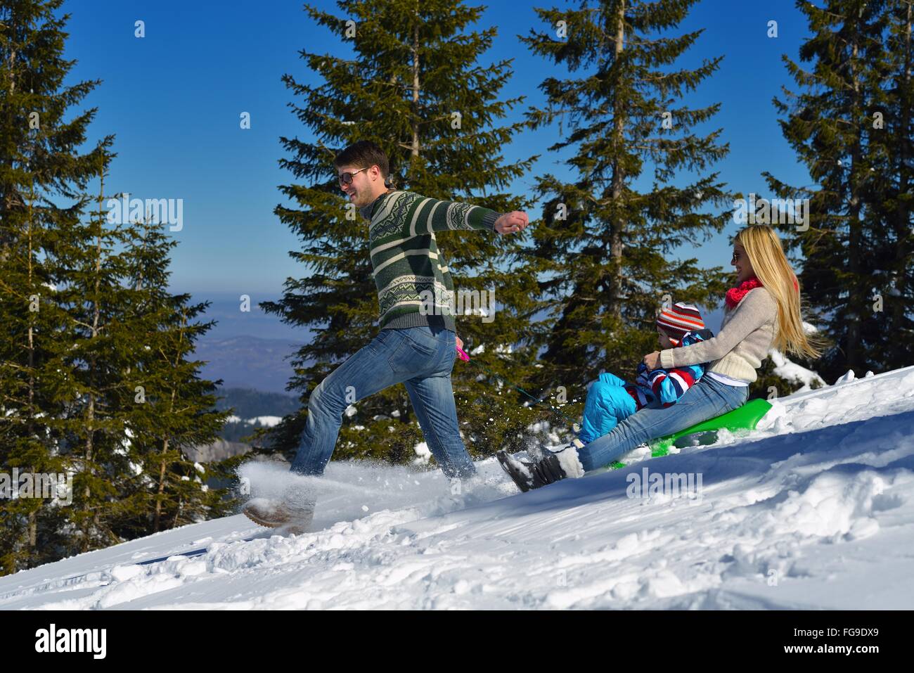 family having fun on fresh snow at winter vacation Stock Photo - Alamy