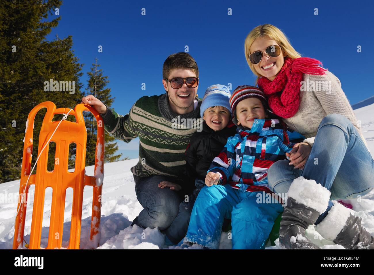family having fun on fresh snow at winter vacation Stock Photo - Alamy