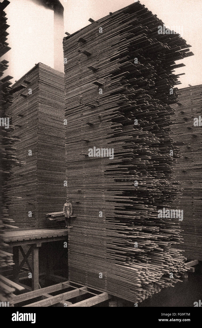 A man stands next the stacks of lumber at Cedar Mill Seattle 1919 Stock ...