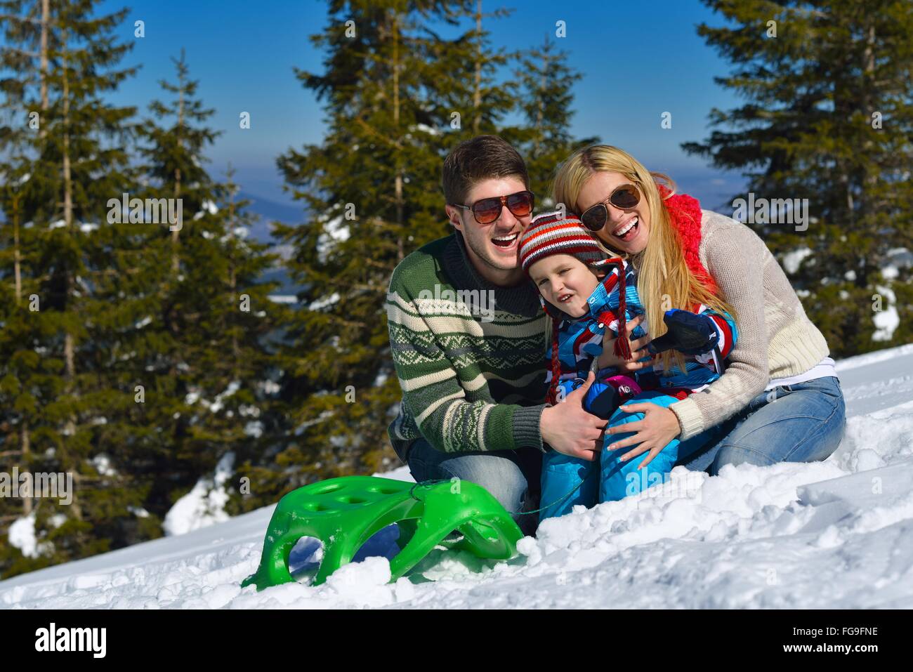 family having fun on fresh snow at winter vacation Stock Photo - Alamy
