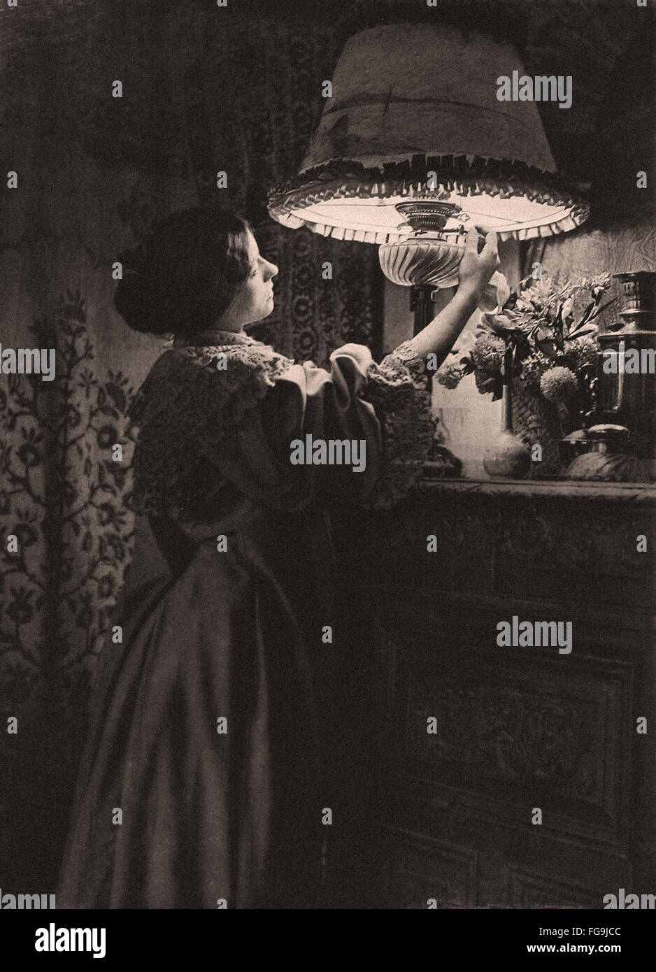 woman lighting a lamp - Pictorialism photography Stock Photo - Alamy