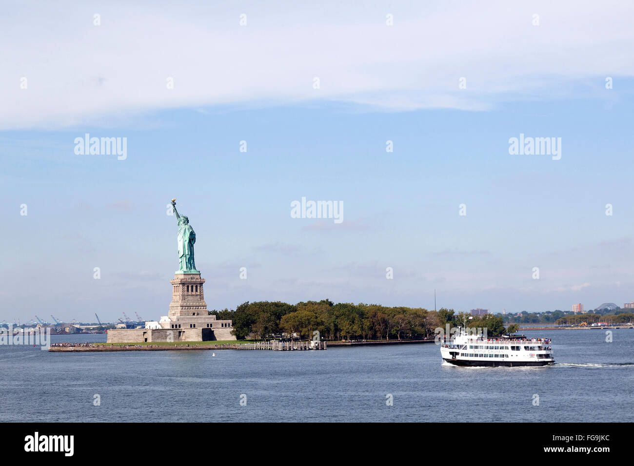 statue of miss liberty in new york city with blue sky and tourist boat ...