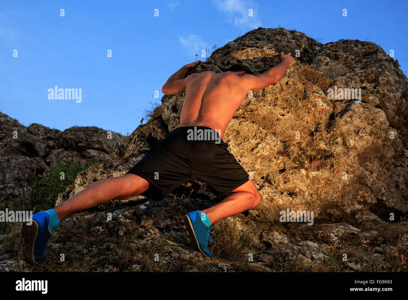 Young man climbing the mountain ridge Stock Photo - Alamy