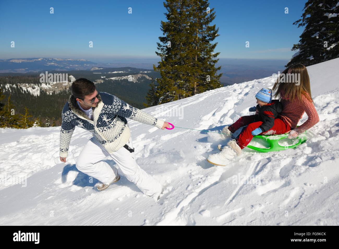 family having fun on fresh snow at winter vacation Stock Photo - Alamy
