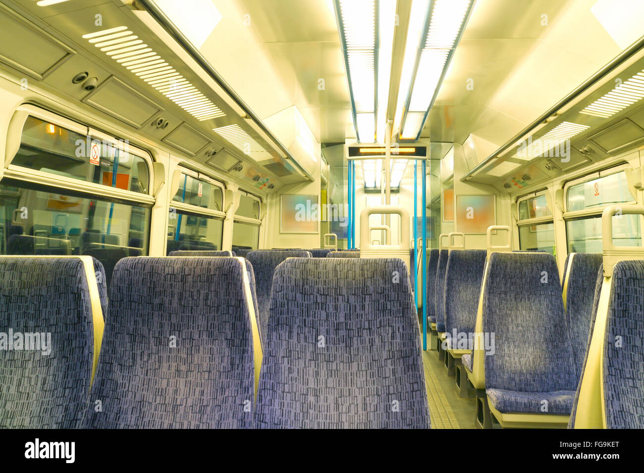 Empty passenger commuting train carriage interior with rows of blue ...