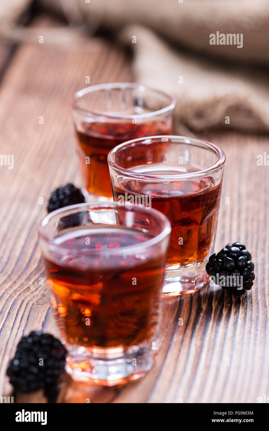 Blackberry Liqueur shot (with some fresh fruits) on wooden background ...
