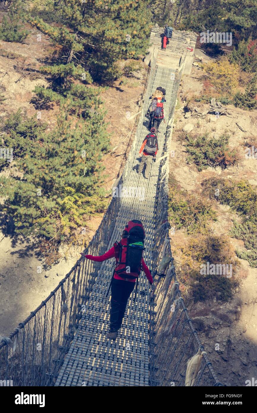 Trekkers crossing a suspension bridge Stock Photo - Alamy