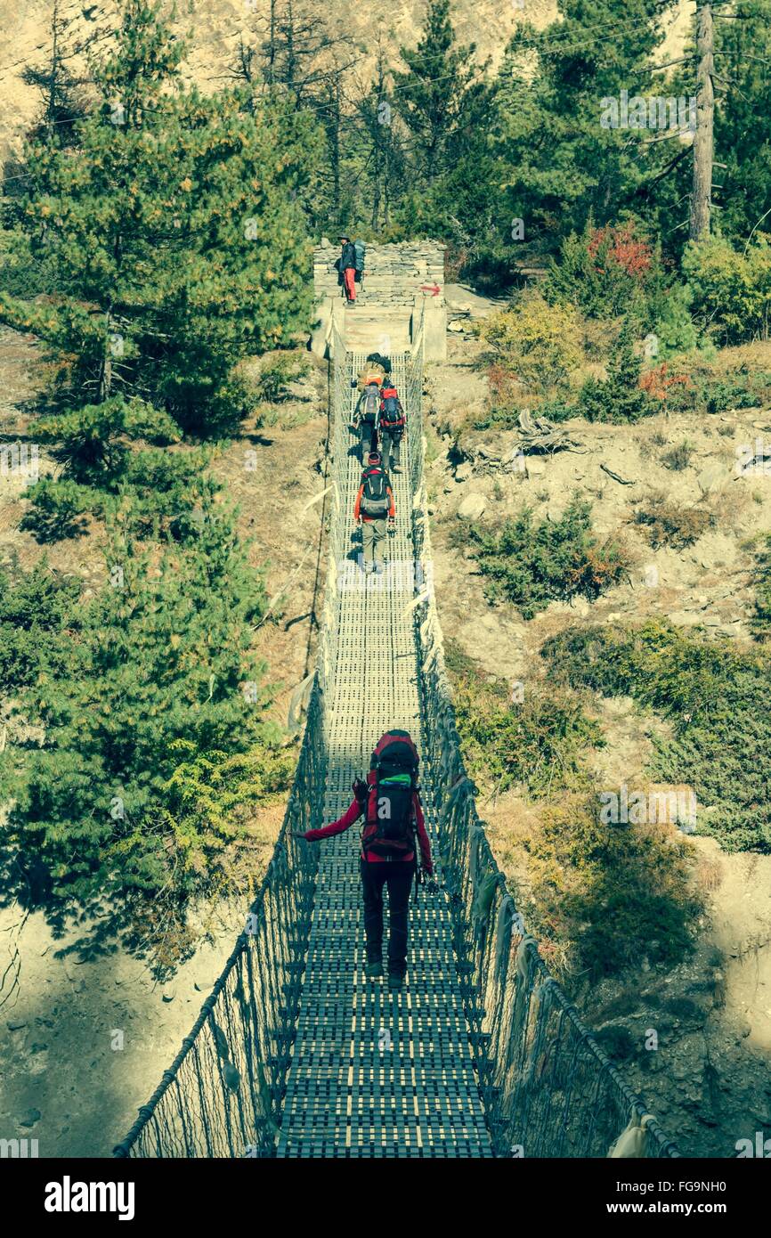 Trekkers crossing a suspension bridge Stock Photo - Alamy