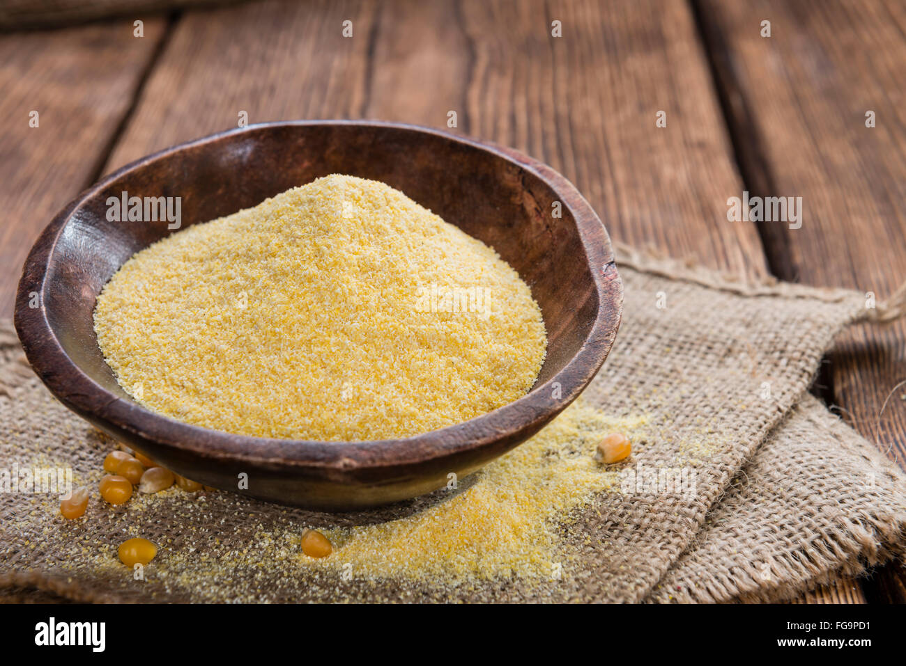 Portion of Cornmeal (on rustic background) as detailed close-up shot ...