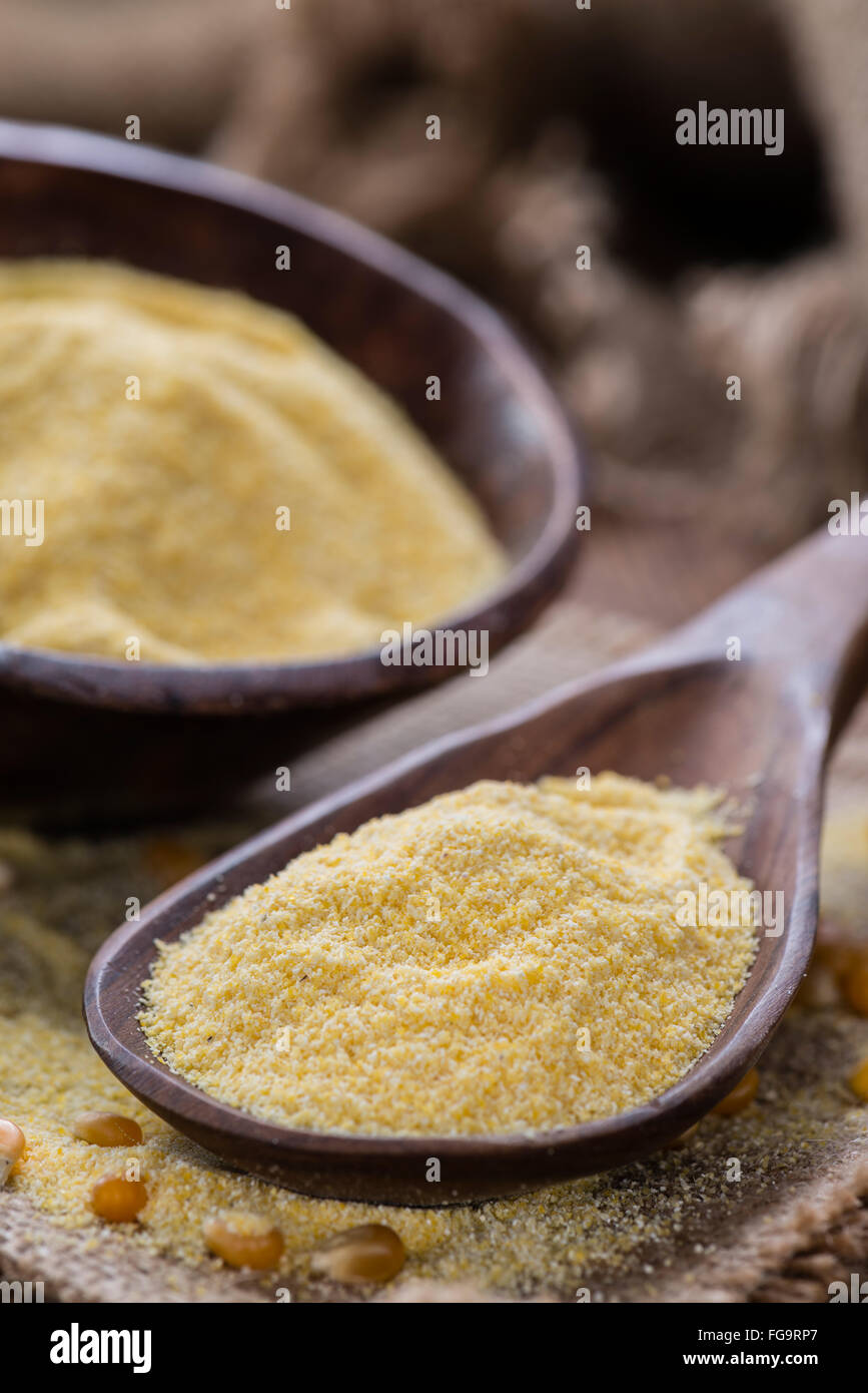 Portion of fresh Cornmeal (close-up shot) on rustic wooden background ...