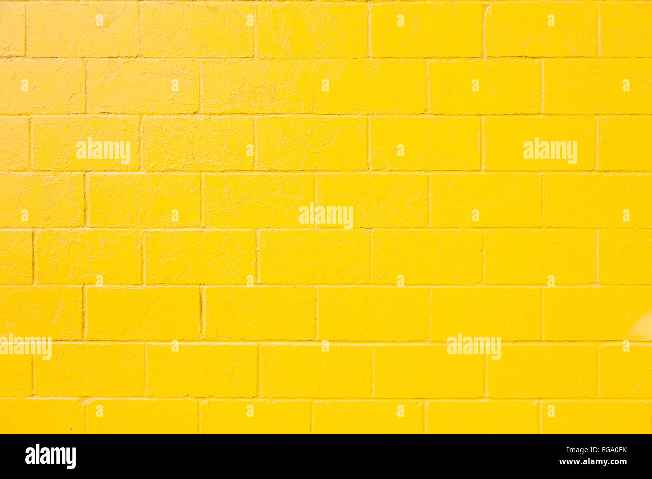 horizontal part of bright yellow painted brick block wall Stock Photo ...